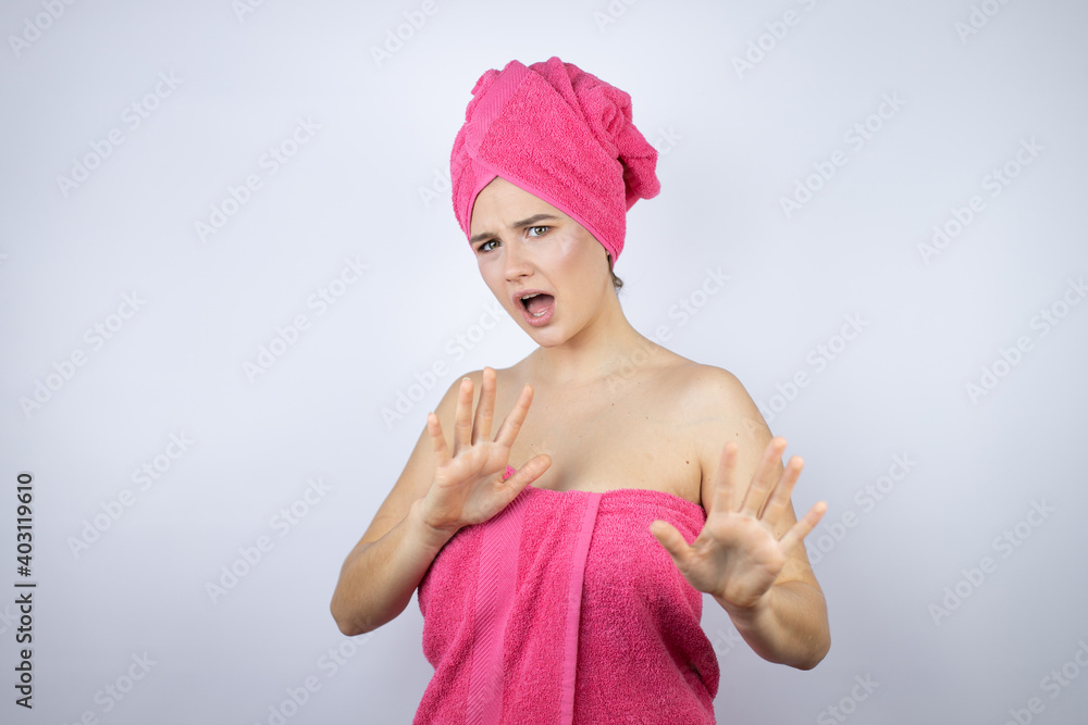 Young beautiful woman wearing shower towel after bath standing over ...
