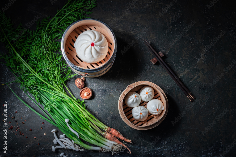 Chinese steamed buns on a plate and bamboo baskets.,Chinese traditional ...