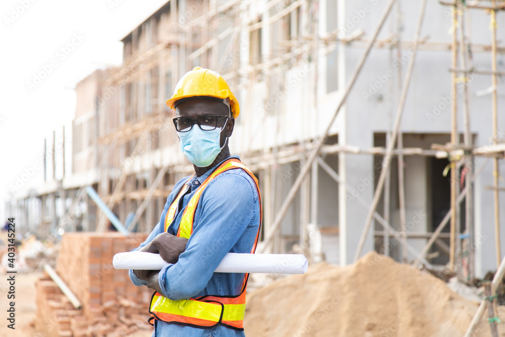 African American construction worker on building site. wearing surgical ...