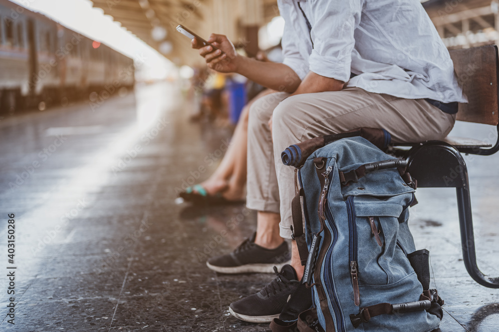 Asian man searching right direction at train station.traveler waiting ...