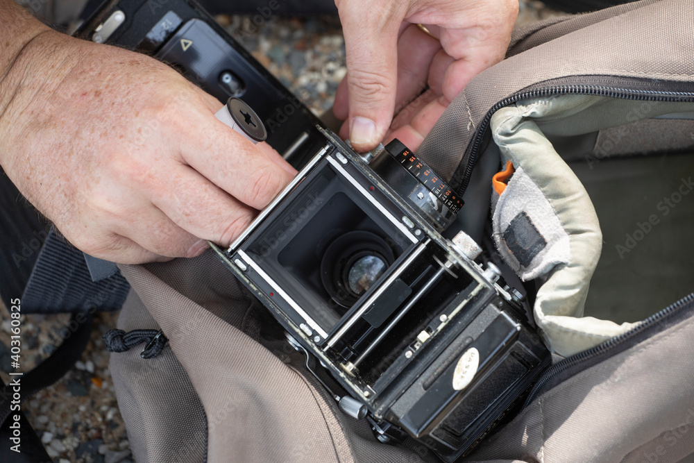 man's hands loading an old twin lens reflex film medium format camera ...