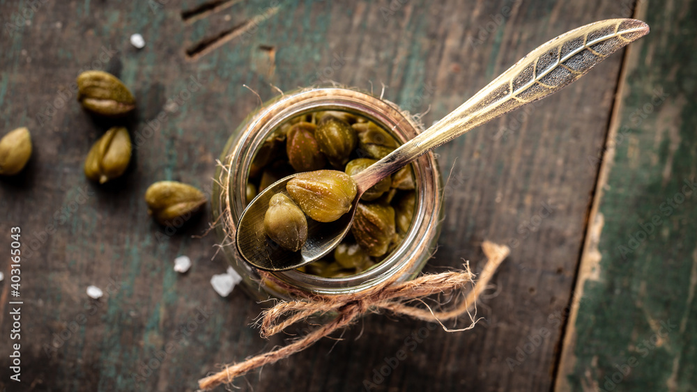 pickled capers on a dark wooden background. Edible flower buds of ...