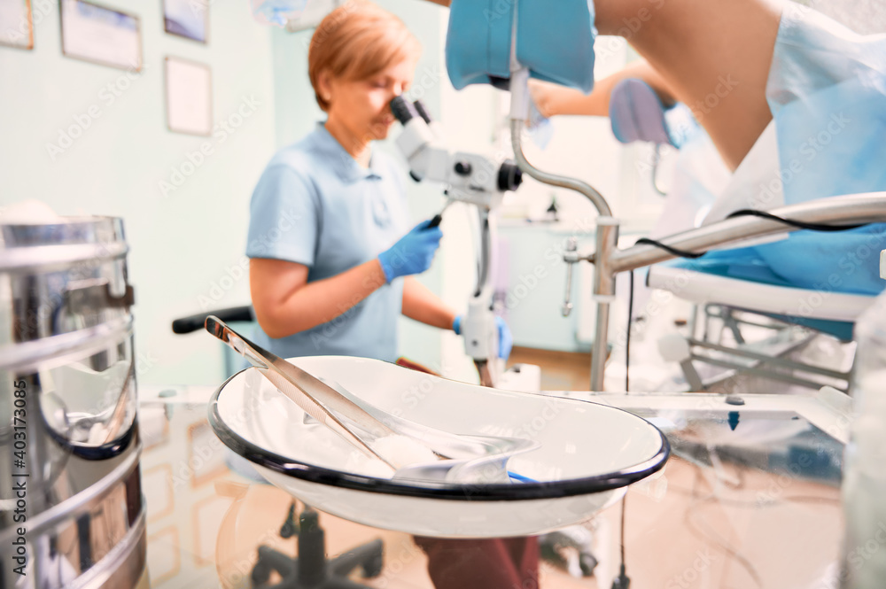 Gynecological Instruments On Foreground Doctor Examining Woman With ...