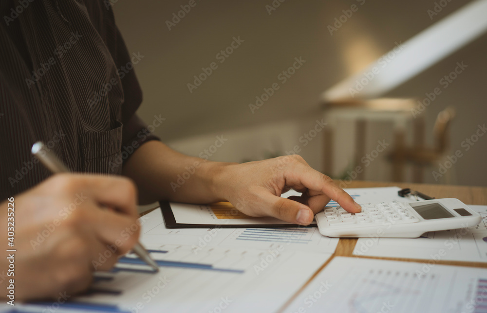 Asian male finance staff Calculating turnover with a calculator From ...