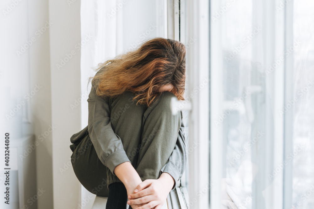 Beautiful sad unhappy teenager girl with curly hair in close pose ...