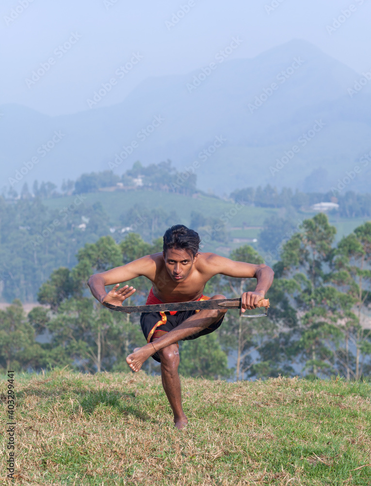 Young Indian fighter balancing with sword during Kalaripayattu martial ...