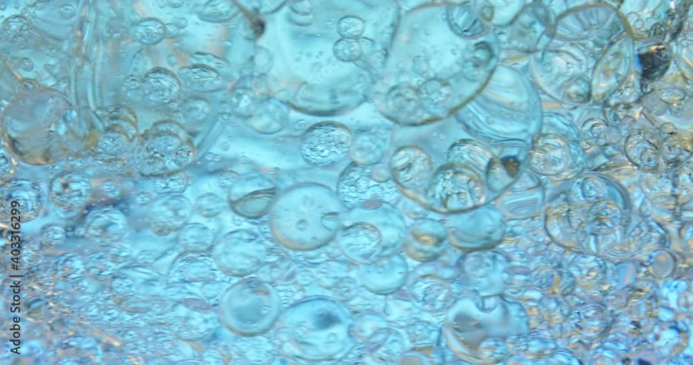 Super slow motion and close up of spoon stirring liquids, fluids, water ...