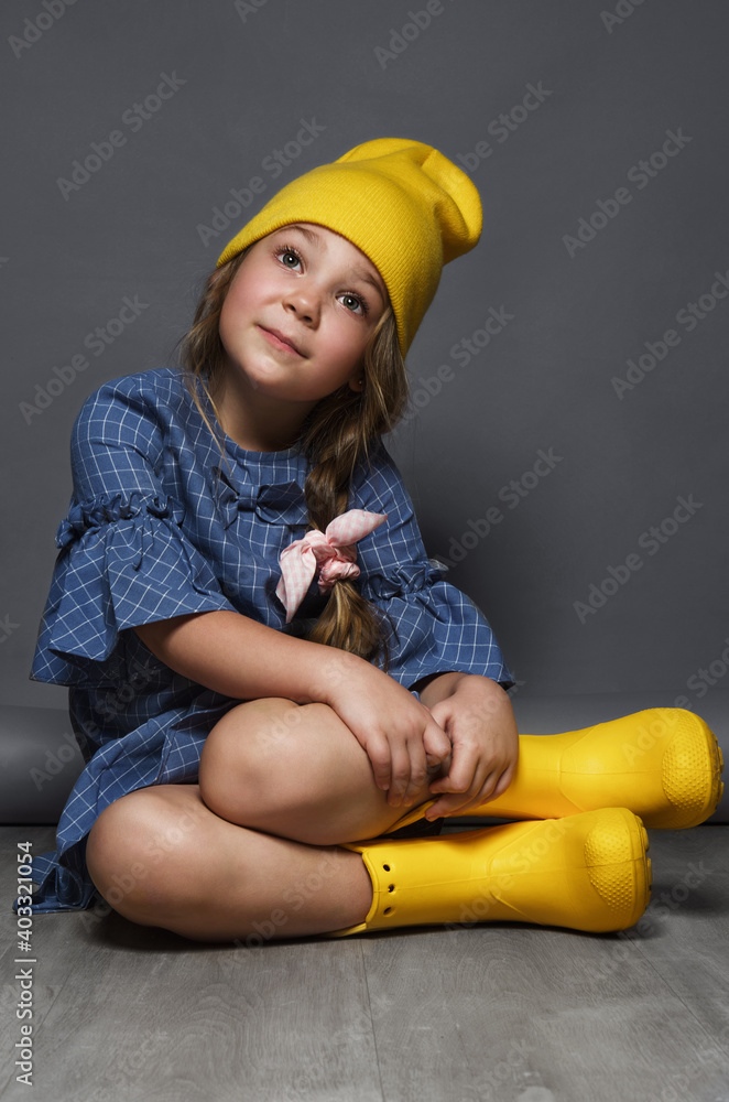 Little girl model professionally posing in the studio in a dress and a ...
