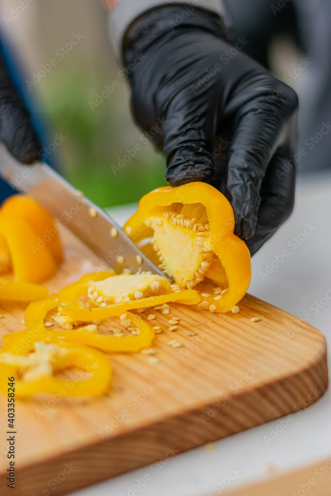 manos con guantes de látex. cortando con cuchillo sobre tabla de madera ...