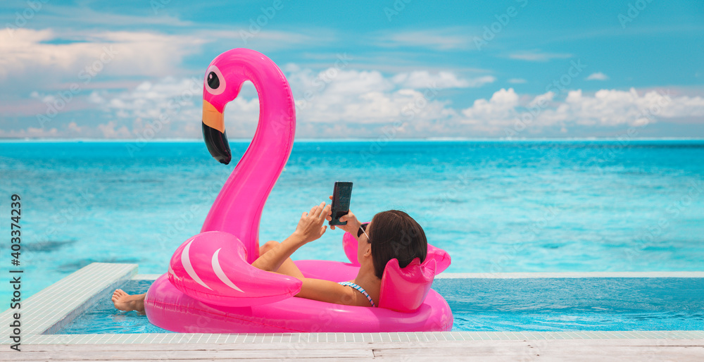 Relaxing woman floating in flamingo inflatable swimming pool toy at ...