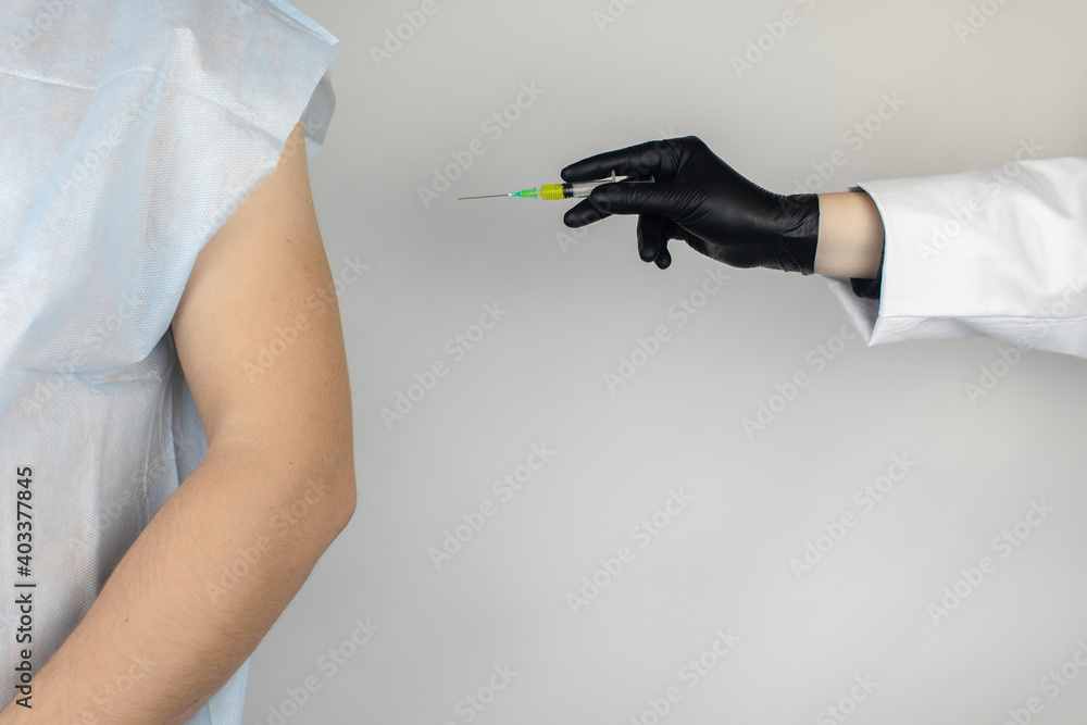 Infectious disease doctor gives the patient a medical vaccination in ...