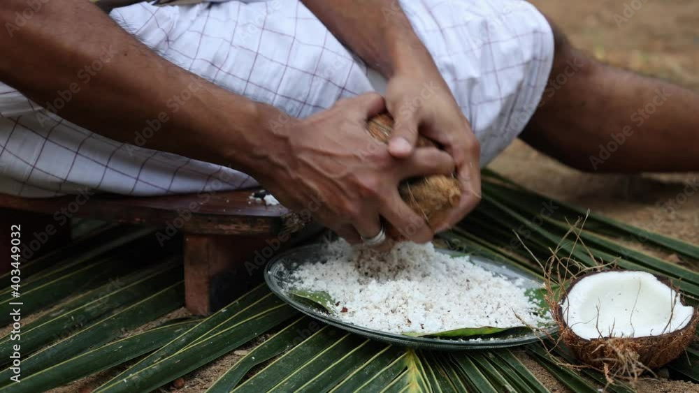 Man hand grating fresh raw coconut cut open in half 4K slow motion ...