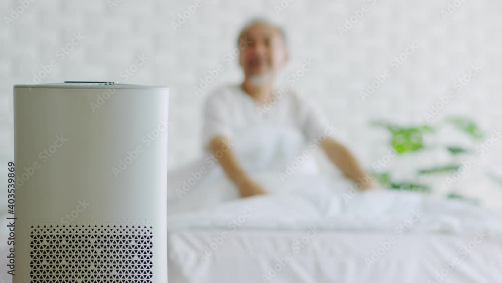 Elderly sleep with Air purifier in cozy white bed room for filter and ...