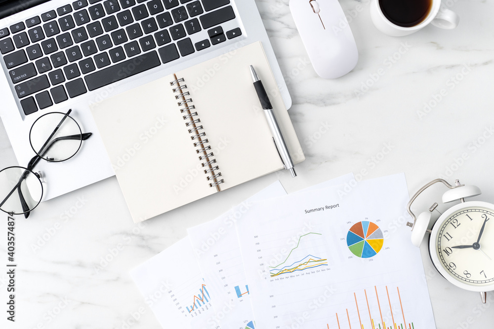 Office table desk work with blank notebook, report and alarm clock on ...