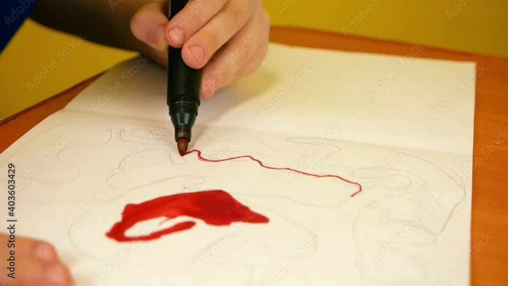Left hand writing theme. Close-up of a child draws with a marker with ...