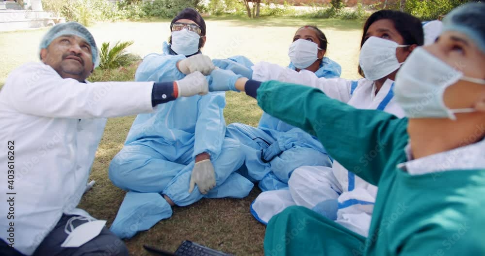 Video „Group of healthcare workers in ppe suits seated bring fists ...