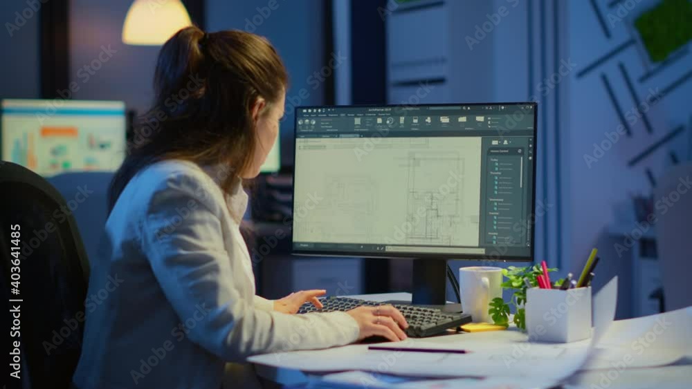 Woman architect matching digital plans from pc with blueprints working ...