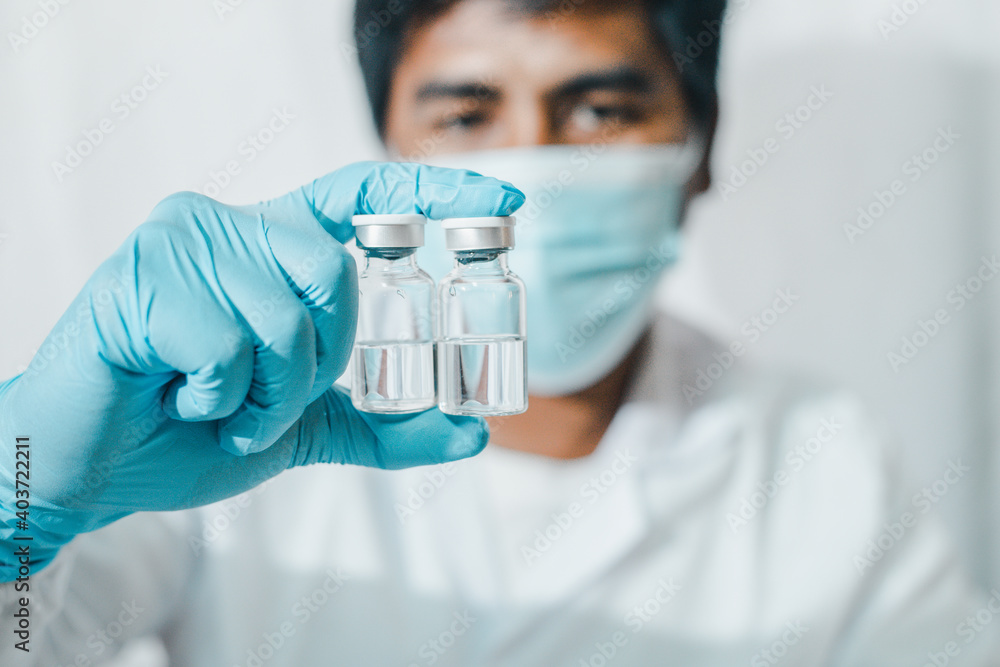 Virus protection concept The doctor's hand held a transparent ampoule ...