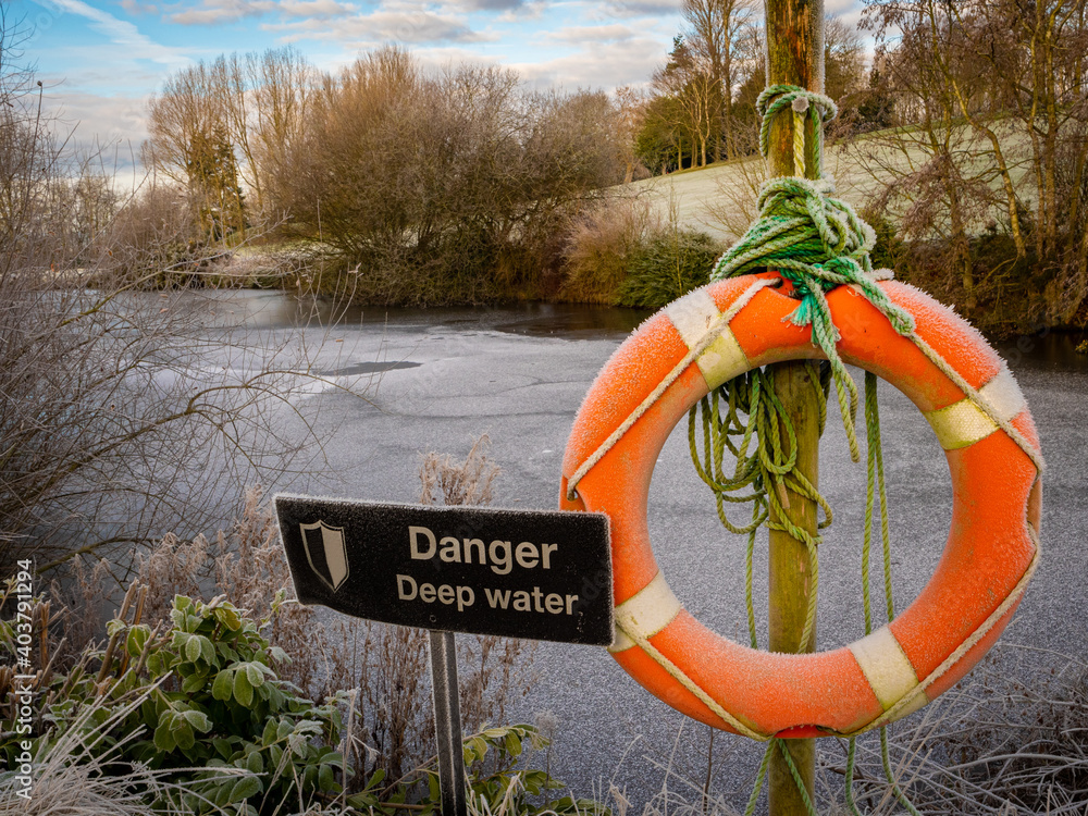 A lifebelt and safety sign warn of danger from drowning in the deep ...