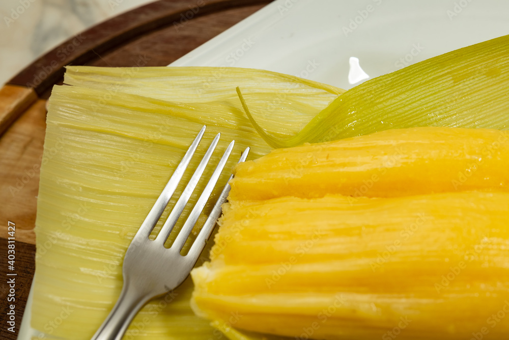 Pamonha - comida típica brasileira; Uma pamonha com a palha do milho ...