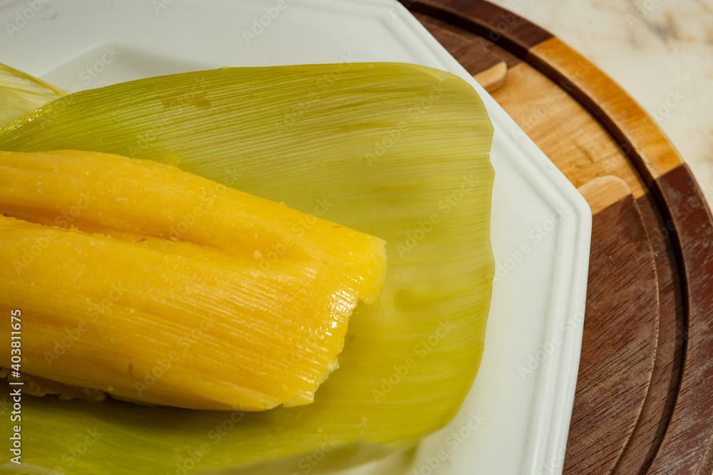 Pamonha - comida típica brasileira; Uma pamonha com a palha do milho ...