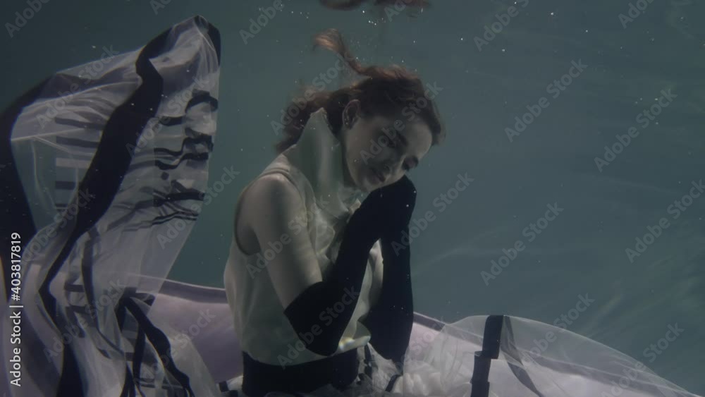 charming lady is dressed gorgeous gown is drinking tea underwater ...