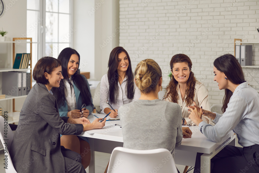 Group of women in their 20s and 30s meeting around office table. Team ...