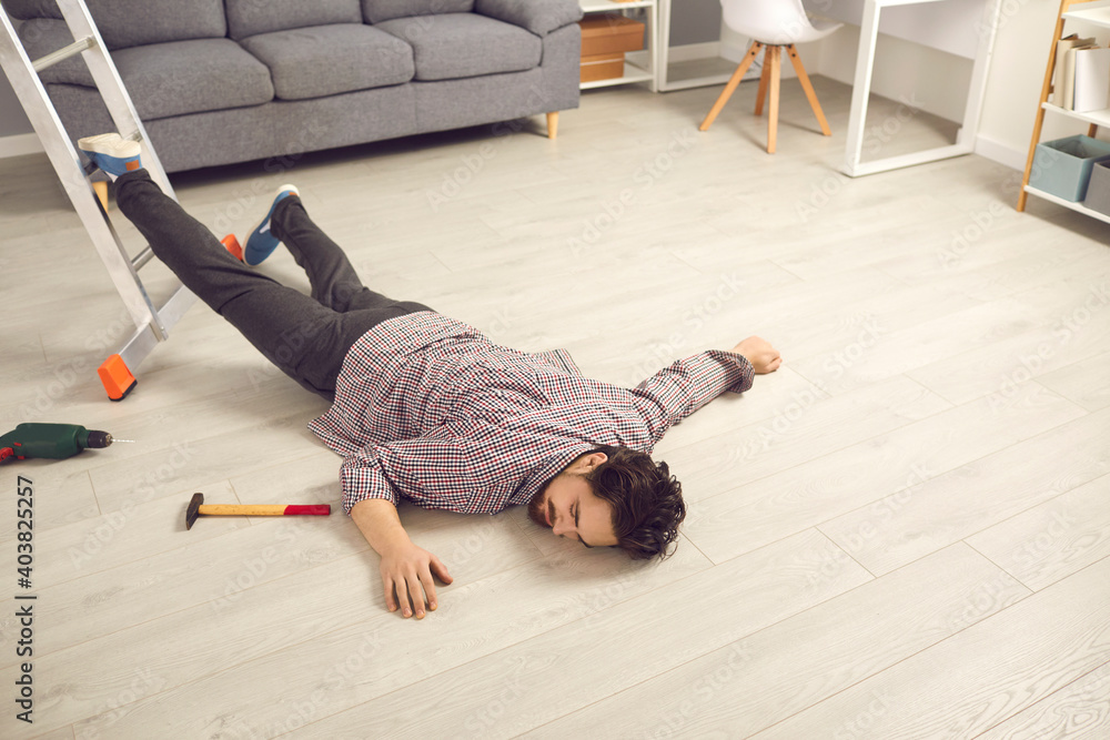 Foto de Young man fallen from ladder lying unconscious on floor ...