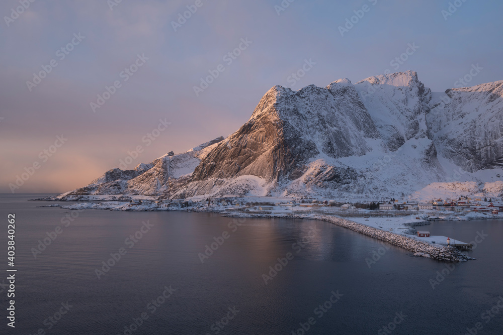 Winter sunrise shines over Reinebringen and village of Reine, Moskenes√ ...