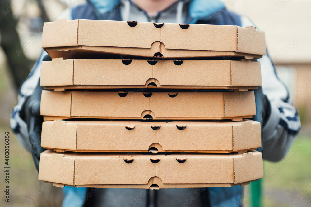 Man delivering pizza. A Deliveryman is holding a large stack of pizza ...