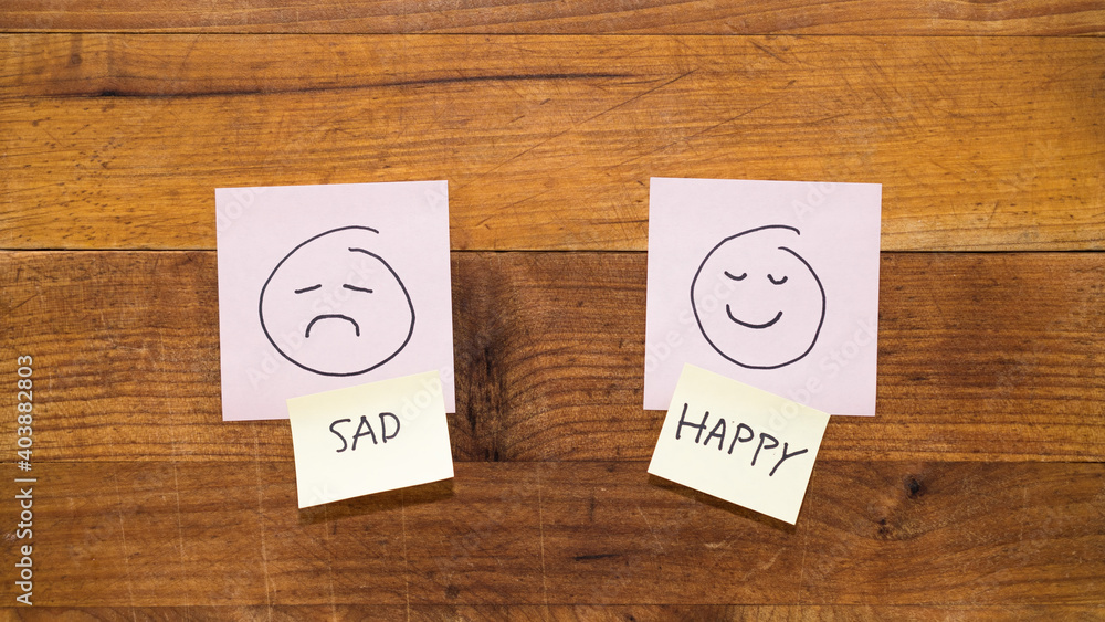 Sticky note happy and sad face emotions on wooden wall background ...