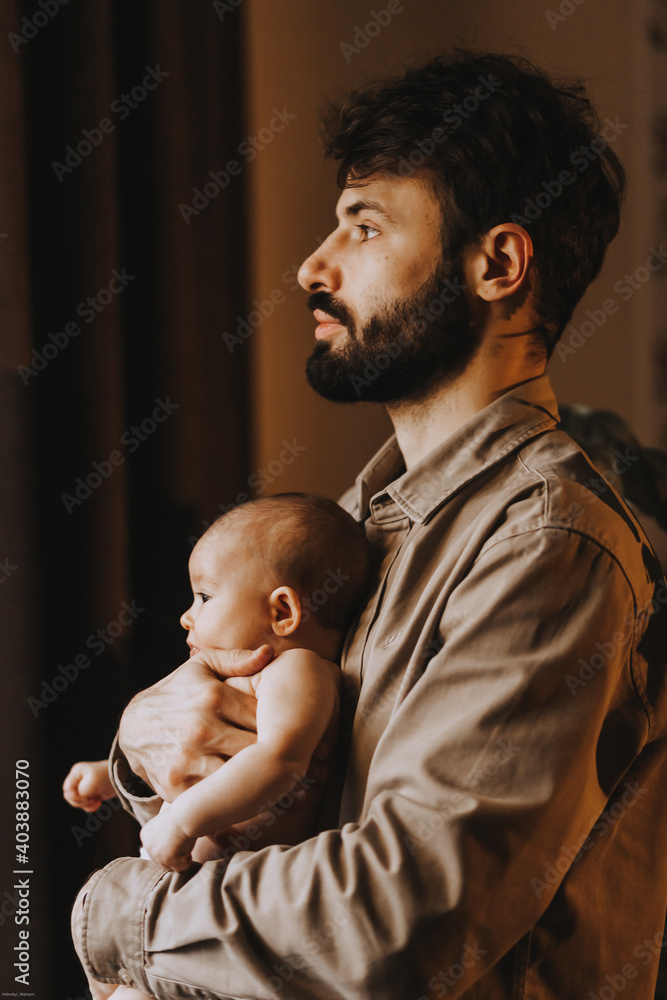 Stylish Caucasian bearded father carrying newborn baby on shoulder ...