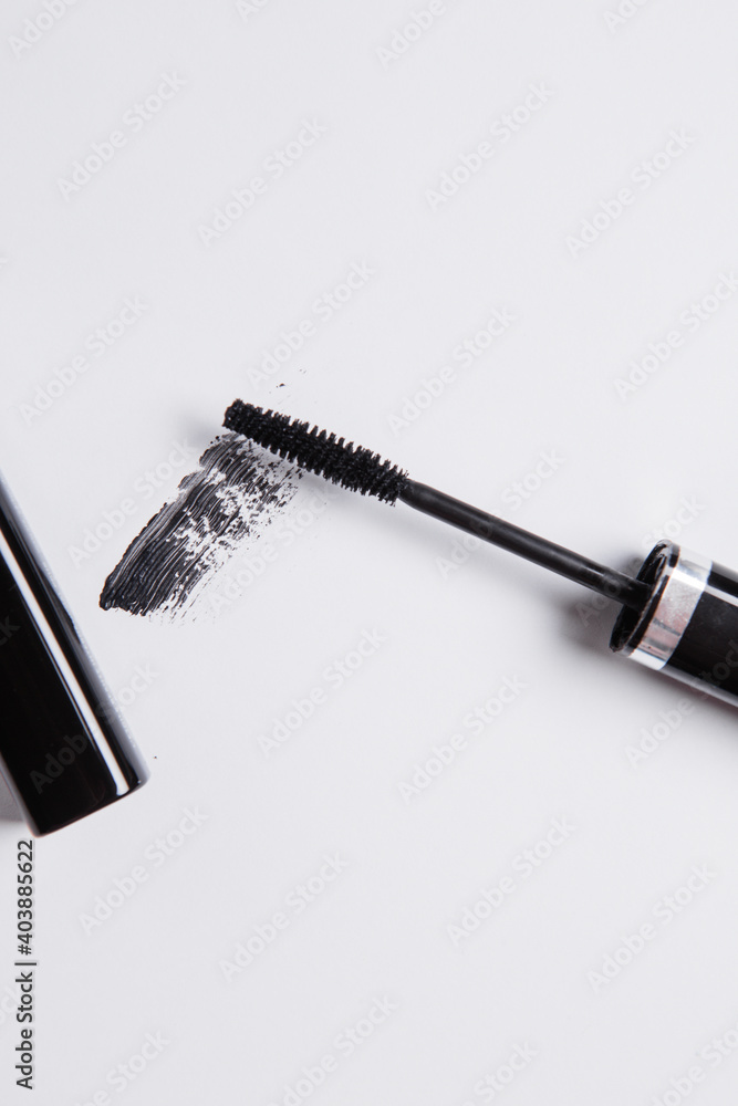 smear of black mascara is smeared on a white background, an applicator ...