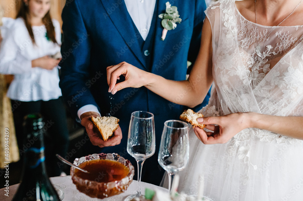 Close Up photo of bride and groom eating traditional loaf. Ukrainian ...