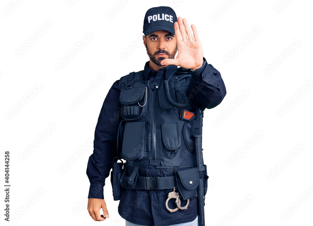 Young hispanic man wearing police uniform doing stop sing with palm of ...