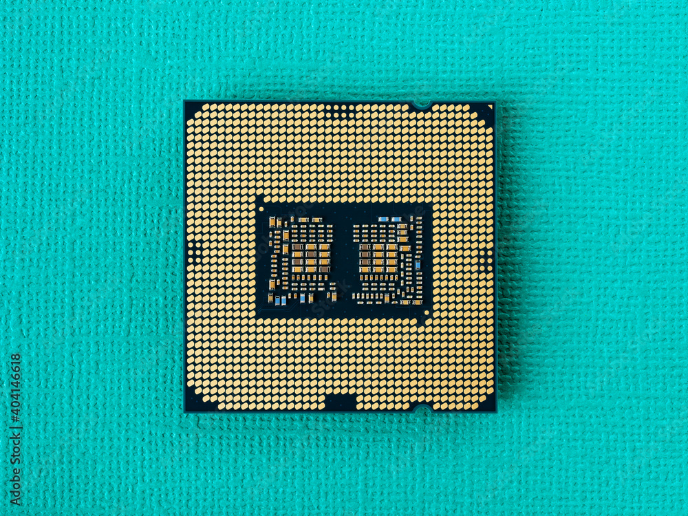 Pc micro CPU with gold plated contacts on a textured turquoise ...