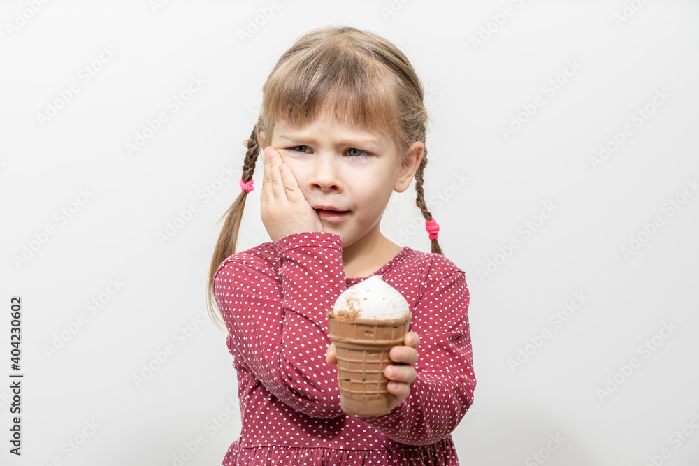 kid girl has a toothache while eating ice cream. sensitivity of teeth ...