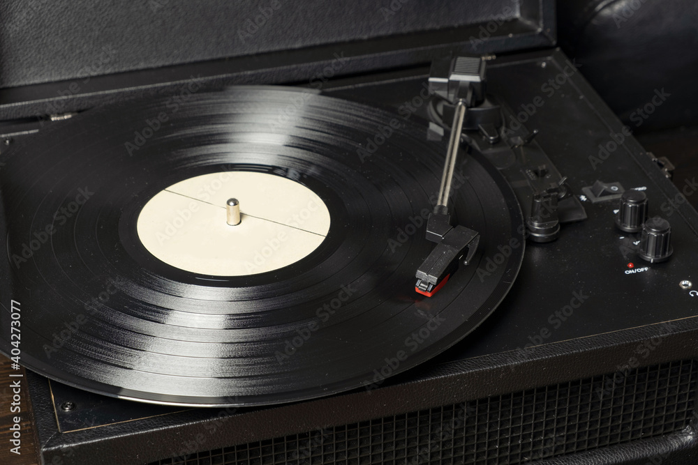 Vintage old retro vinyl electronic record player with black record and ...