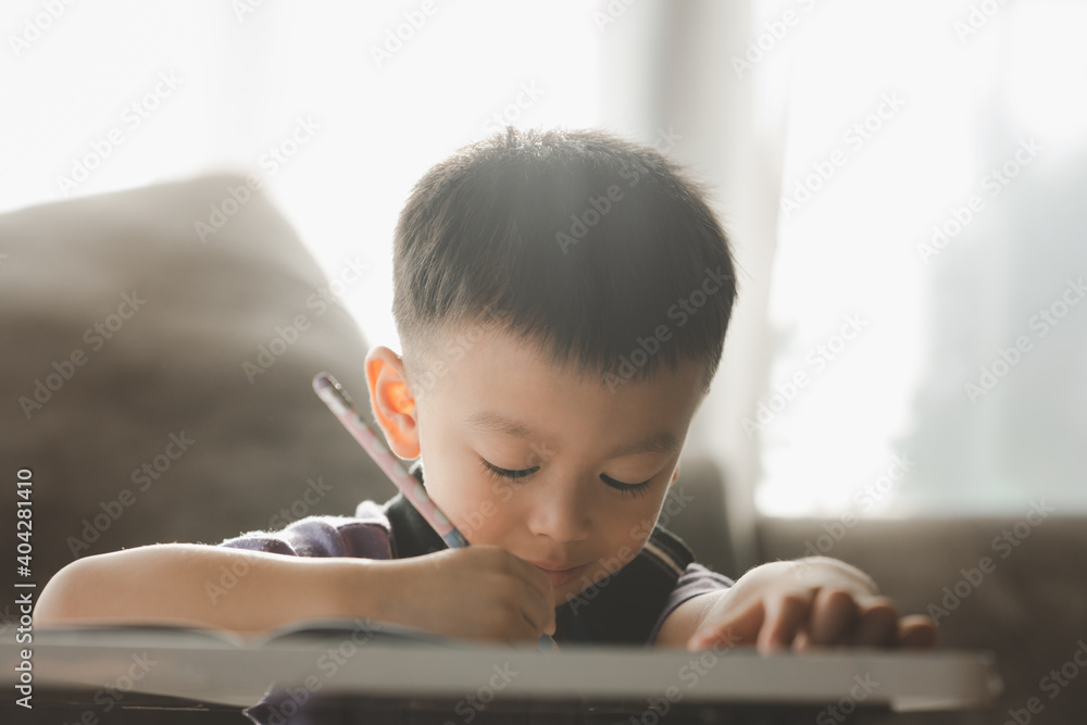 Asian Boy Doing homework with the intention. Child boy holding pencil ...