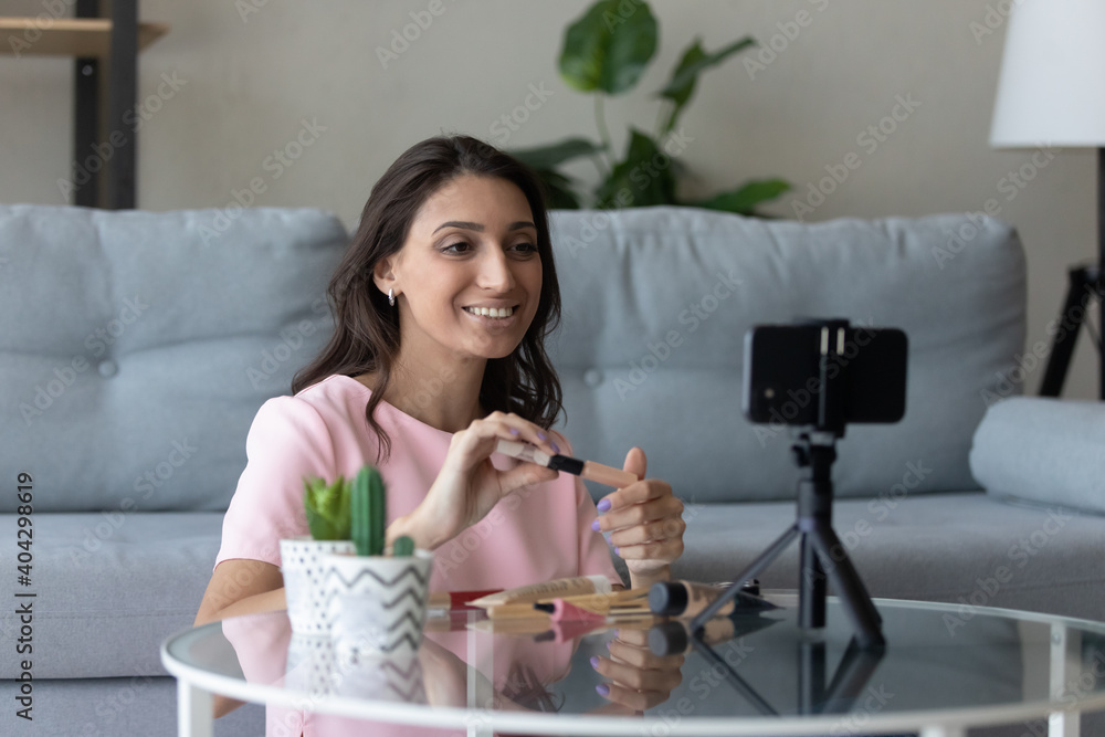 Smiling young indian Arabic female vlogger record makeup tutorial on ...