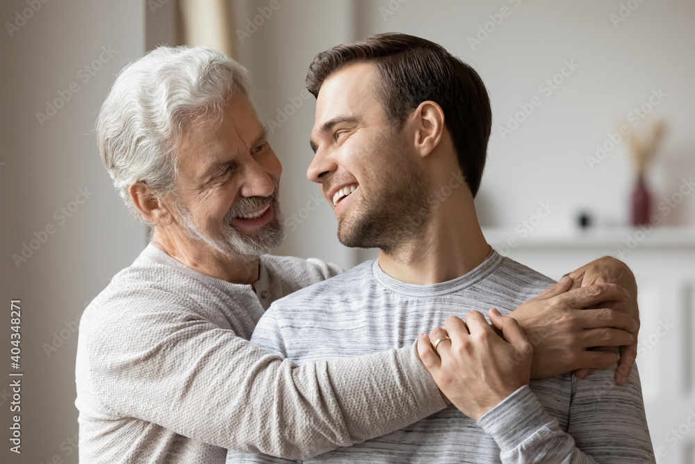 Happy old 70s Caucasian grey-haired dad hug adult son show love and ...
