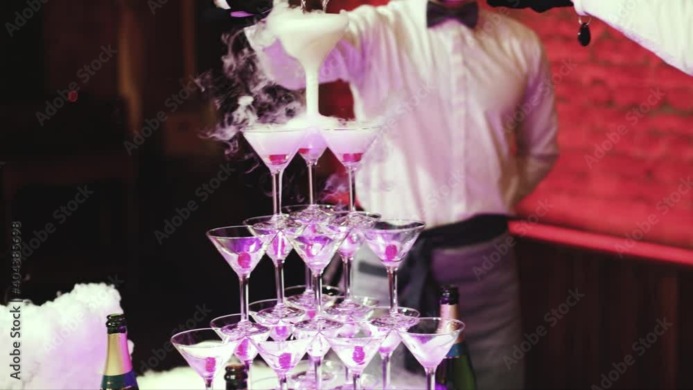 Glasses with alcoholic beverages in the pyramid, filling and pouring ...