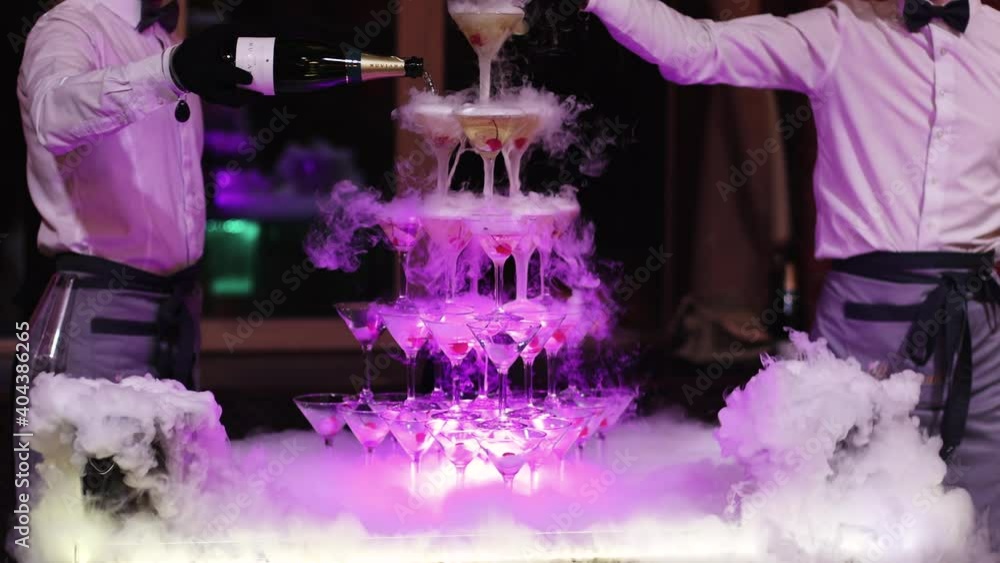 Glasses with alcoholic beverages in the pyramid, filling and pouring ...