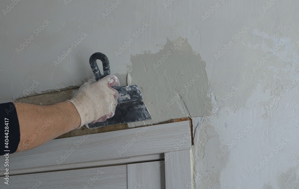 leveling the wall after installing the door frame, applying plaster ...