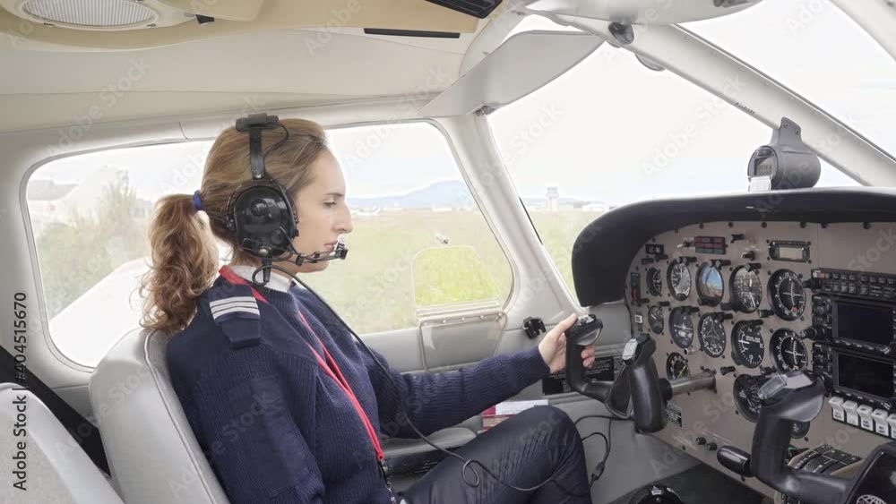 Side view of a female pilot in the cockpit of an airplane. vídeo de ...