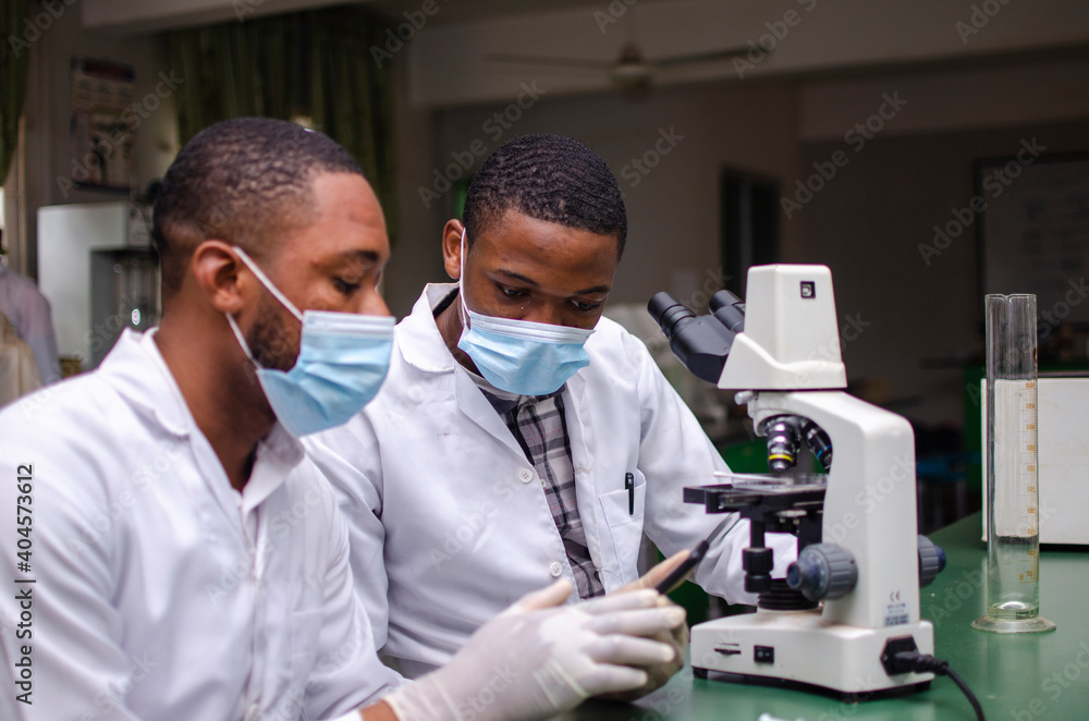 young black laboratory scientists carrying out a blood test for a ...