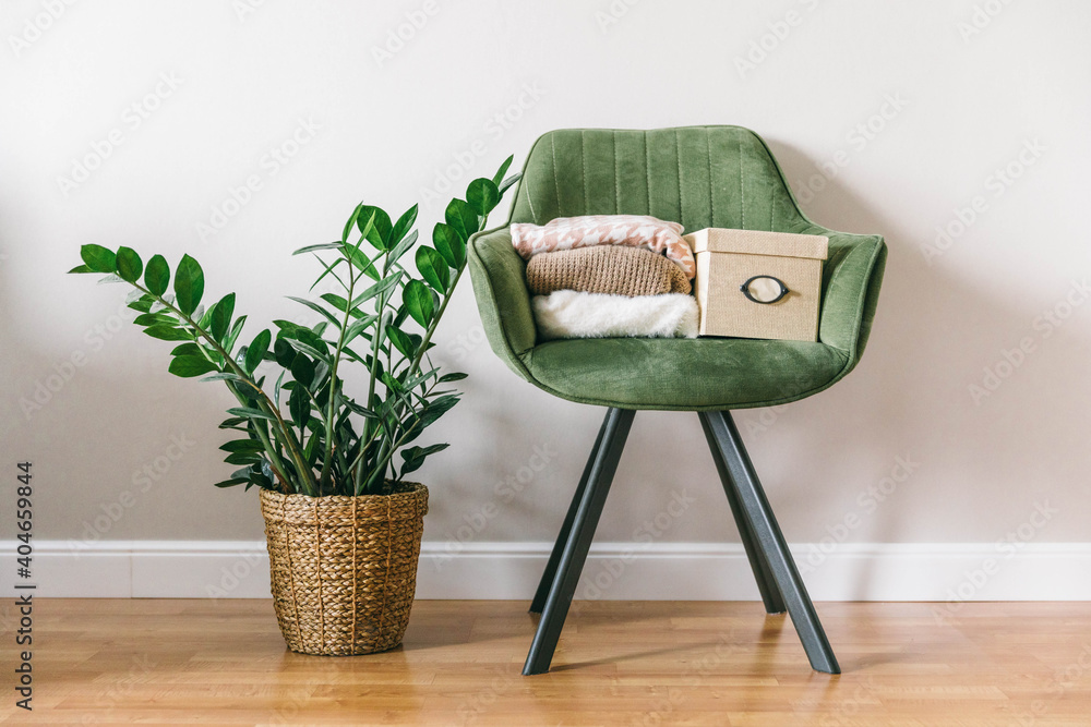 Stack of clothes on a green chair in a light room. Home space ...