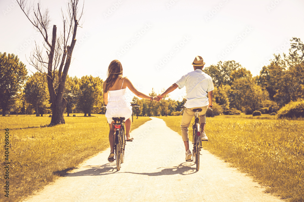 Romantic couple in love cycling in the park - Boyfriend and girlfriend ...