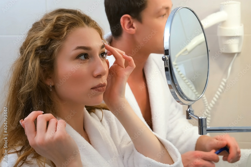 Man and woman bathrobes doing their morning routing together in ...