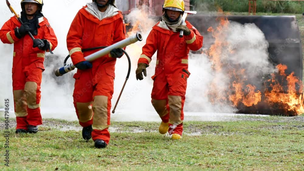 Firefighter fighting with fire flame protection property. Fireman wear ...